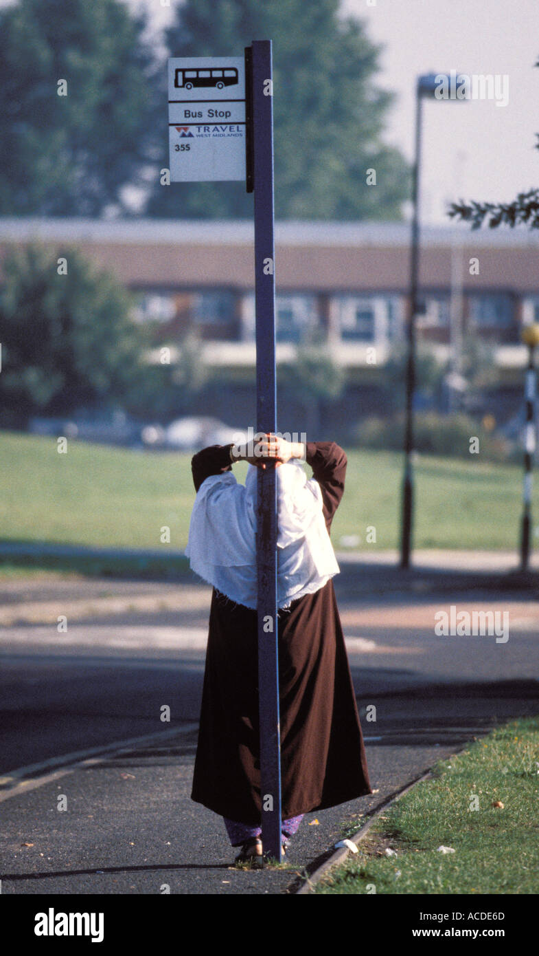 An ethnic woman leaning on a bus stop in the Ladywood area of ...