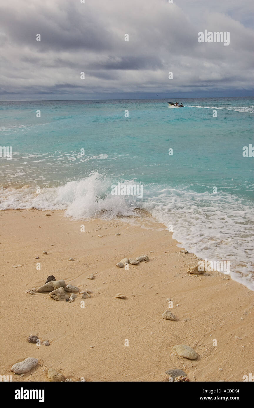 A small boat leaves a beach as storm clouds approach Gielop Island ...