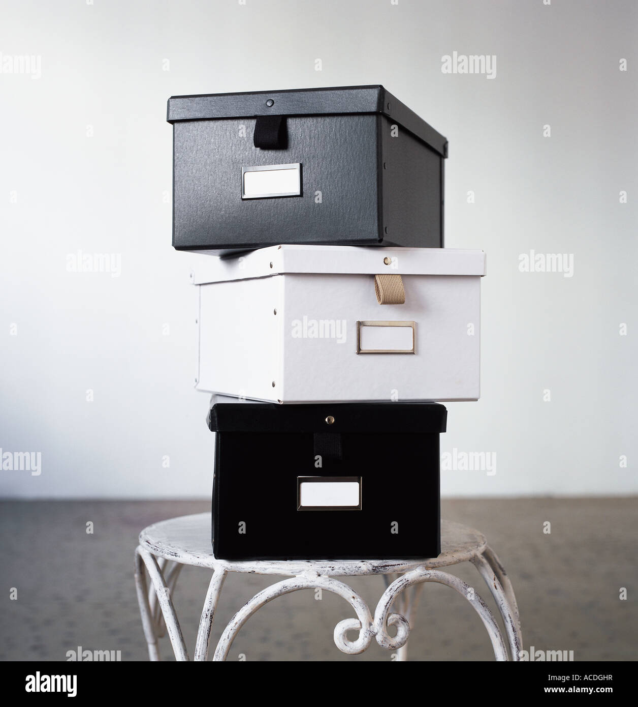 Three boxes on a white stool Stock Photo - Alamy