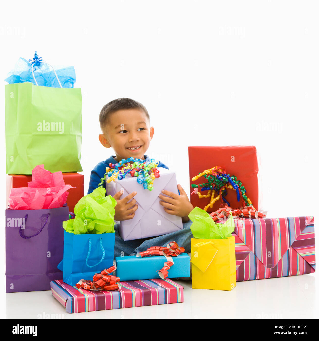 Asian boy sitting smiling with wrapped presents Stock Photo - Alamy