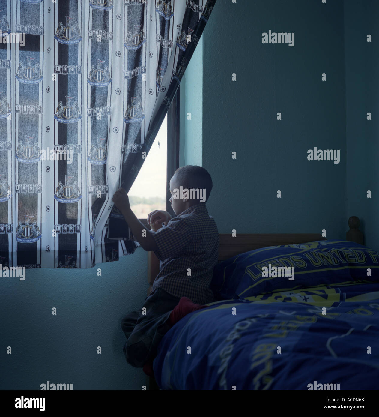 A young boy looks out of his bedroom window, council flat, UK Stock ...