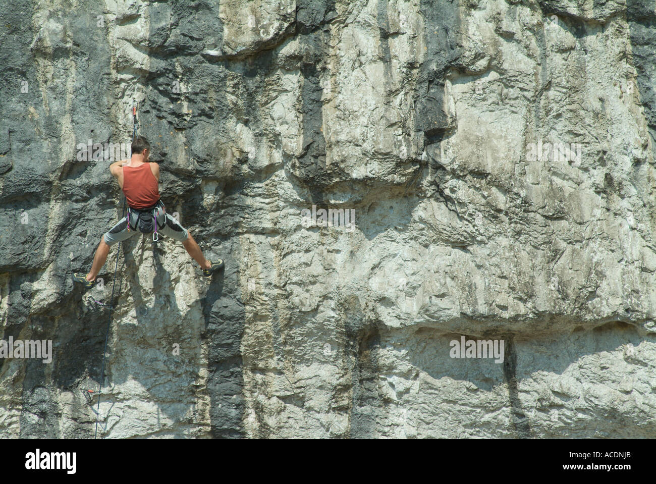 Malham cove climbers practising a climb up a vertical limestone cliff ...