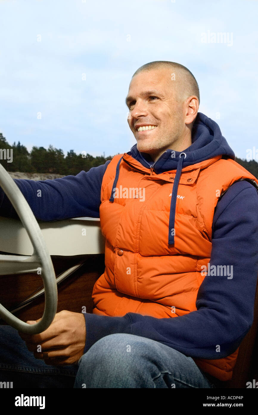 A smiling man driving a motorboat Stock Photo - Alamy