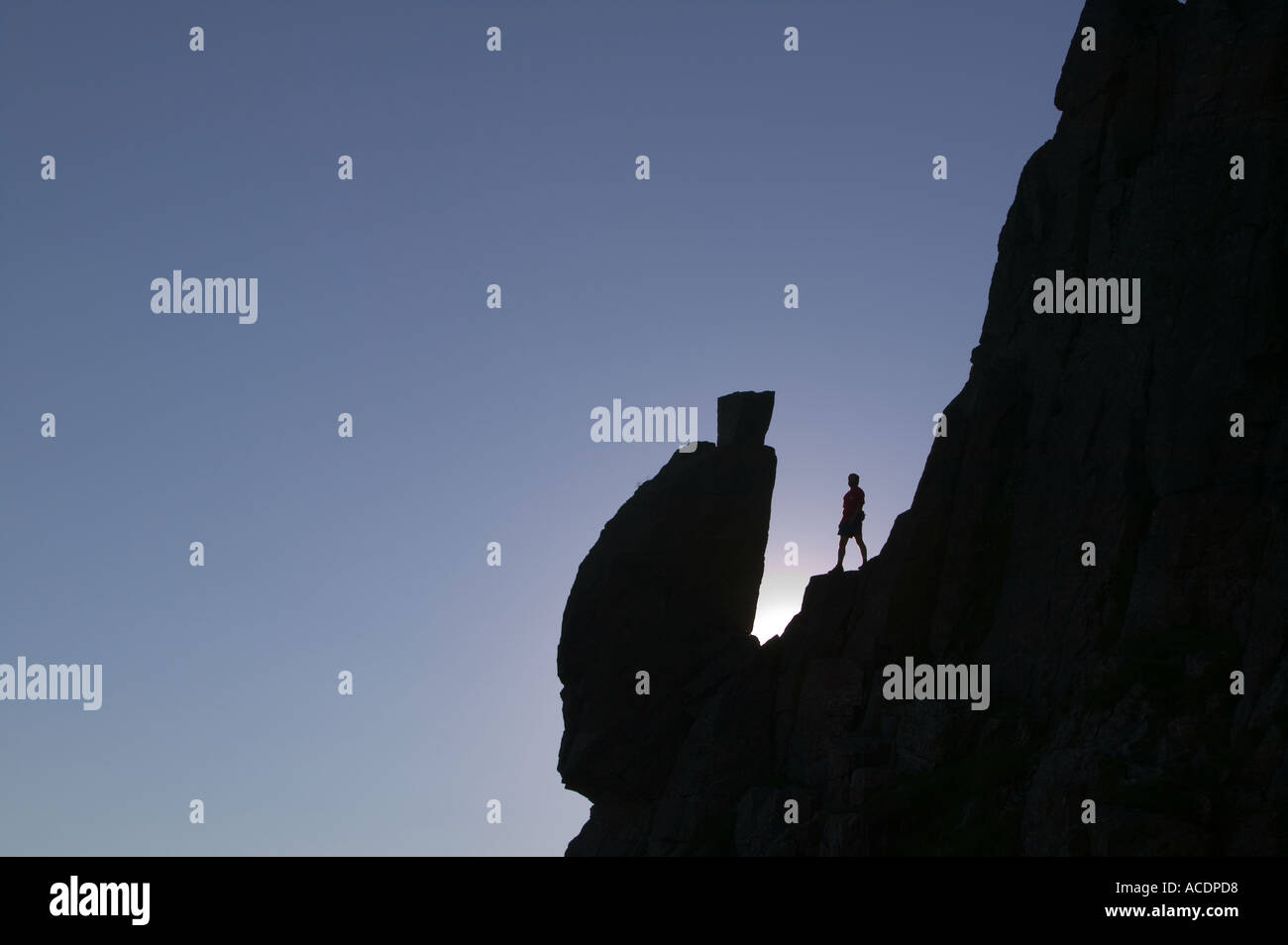 climber silhouetted by The Sphinx rock on Great Gable Lake district ...