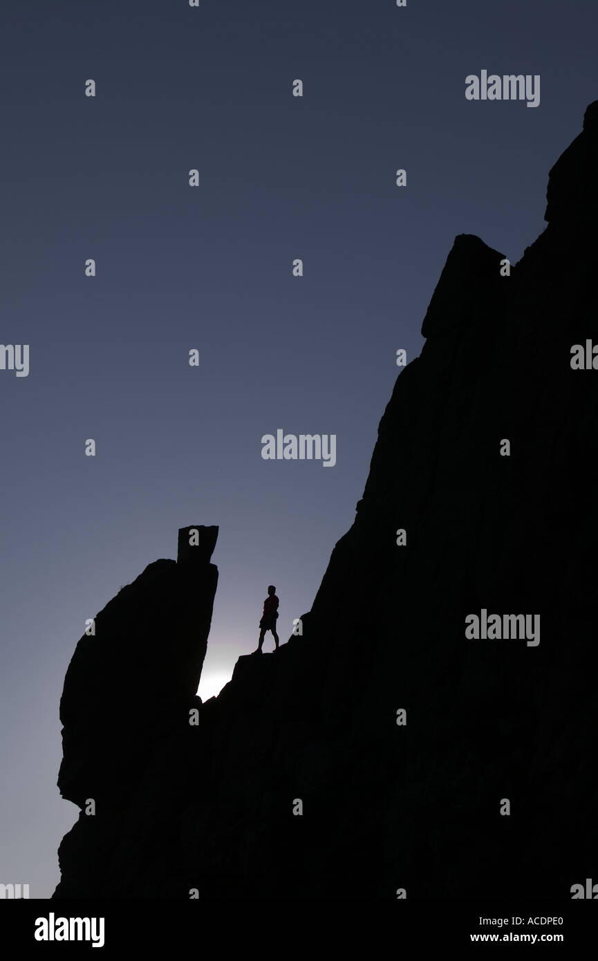 climber silhouetted by The Sphinx rock on Great Gable Lake district ...