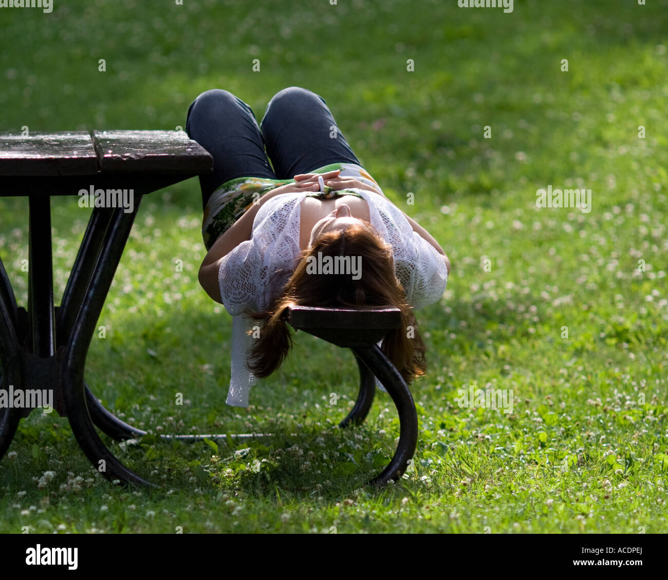 Woman taking a nap on a park bench Stock Photo - Alamy