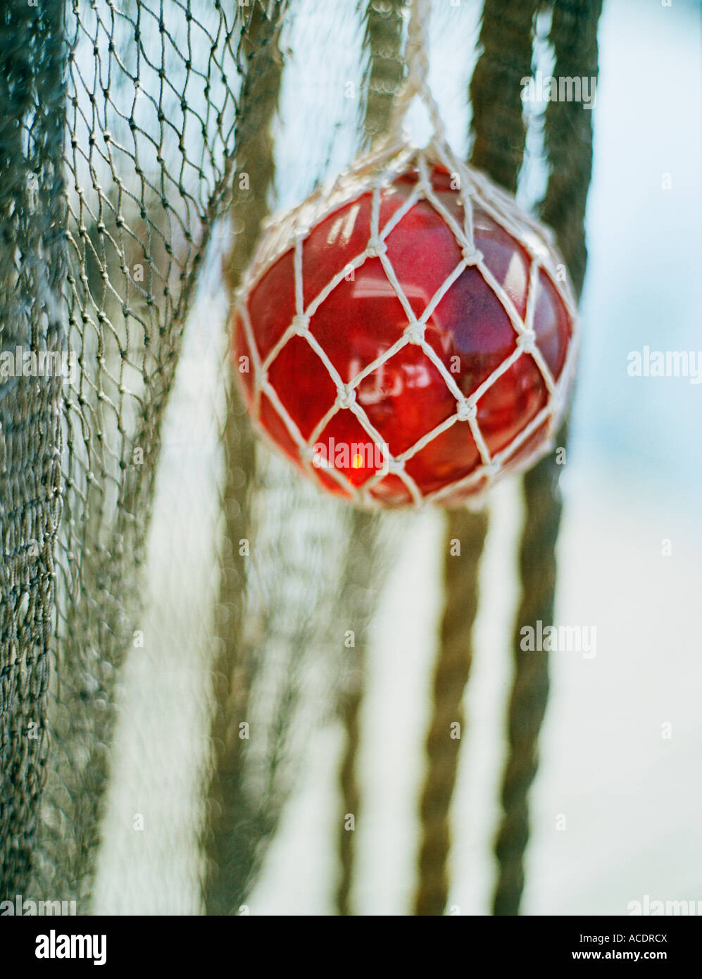 A red glass ball in a net Stock Photo - Alamy