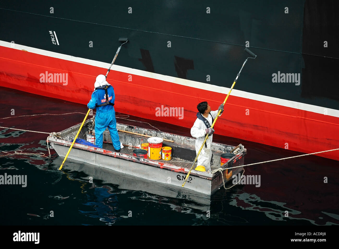 Crewmen performing maintenance while cruise ship is docked in port of ...