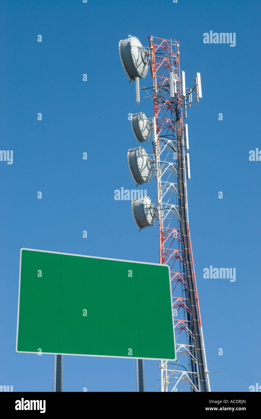 Blank green sign in front of communications tower Stock Photo - Alamy