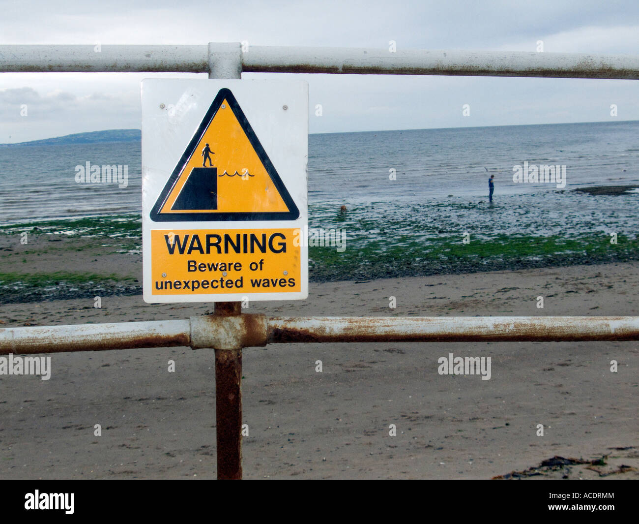beware of unexpected waves sign post at the seaside Stock Photo - Alamy