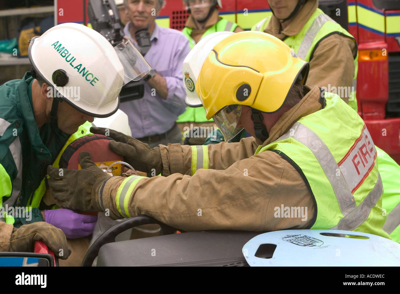 ambulance paramedic and firemen treat an injured driver in a car crash ...
