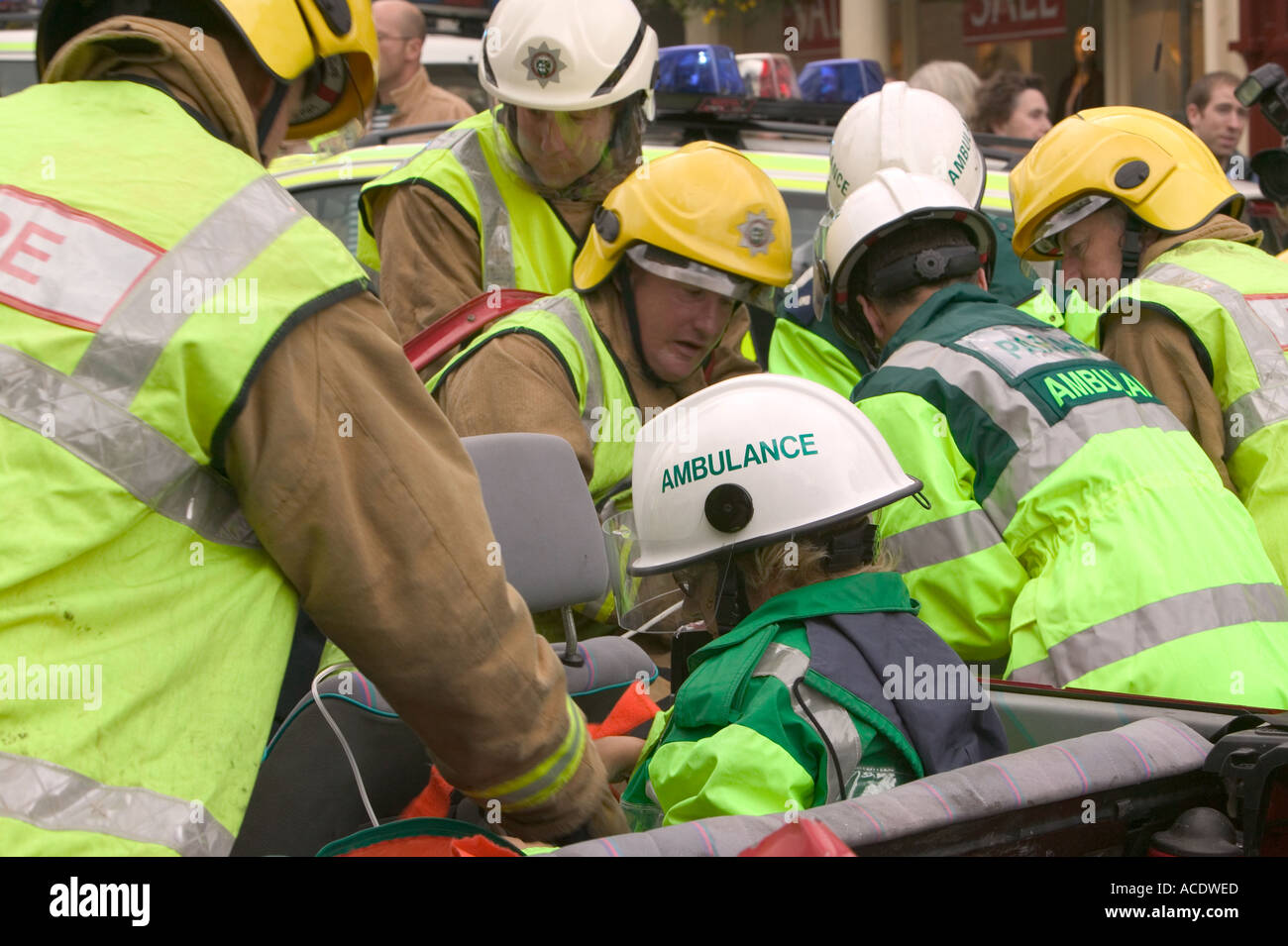 ambulance paramedic and firemen treat an injured driver in a car crash ...