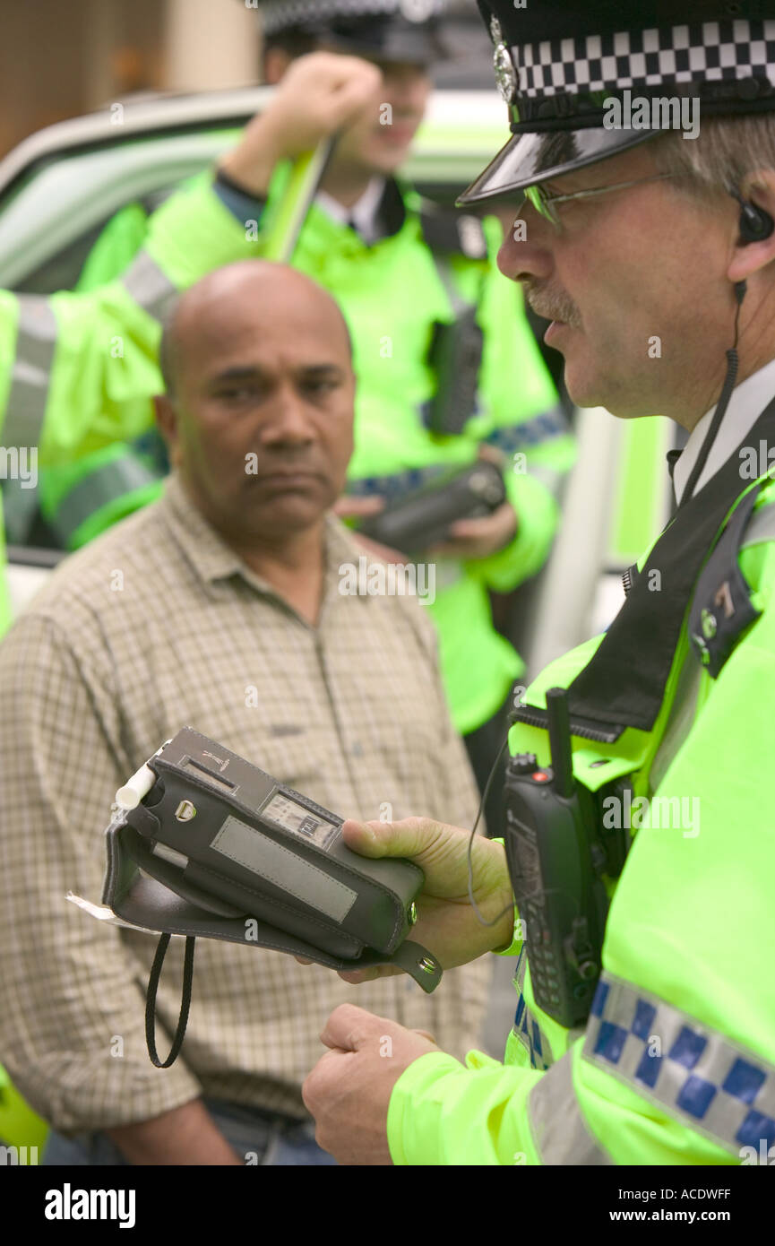 policeman breathalising a member of the public in a road safety ...
