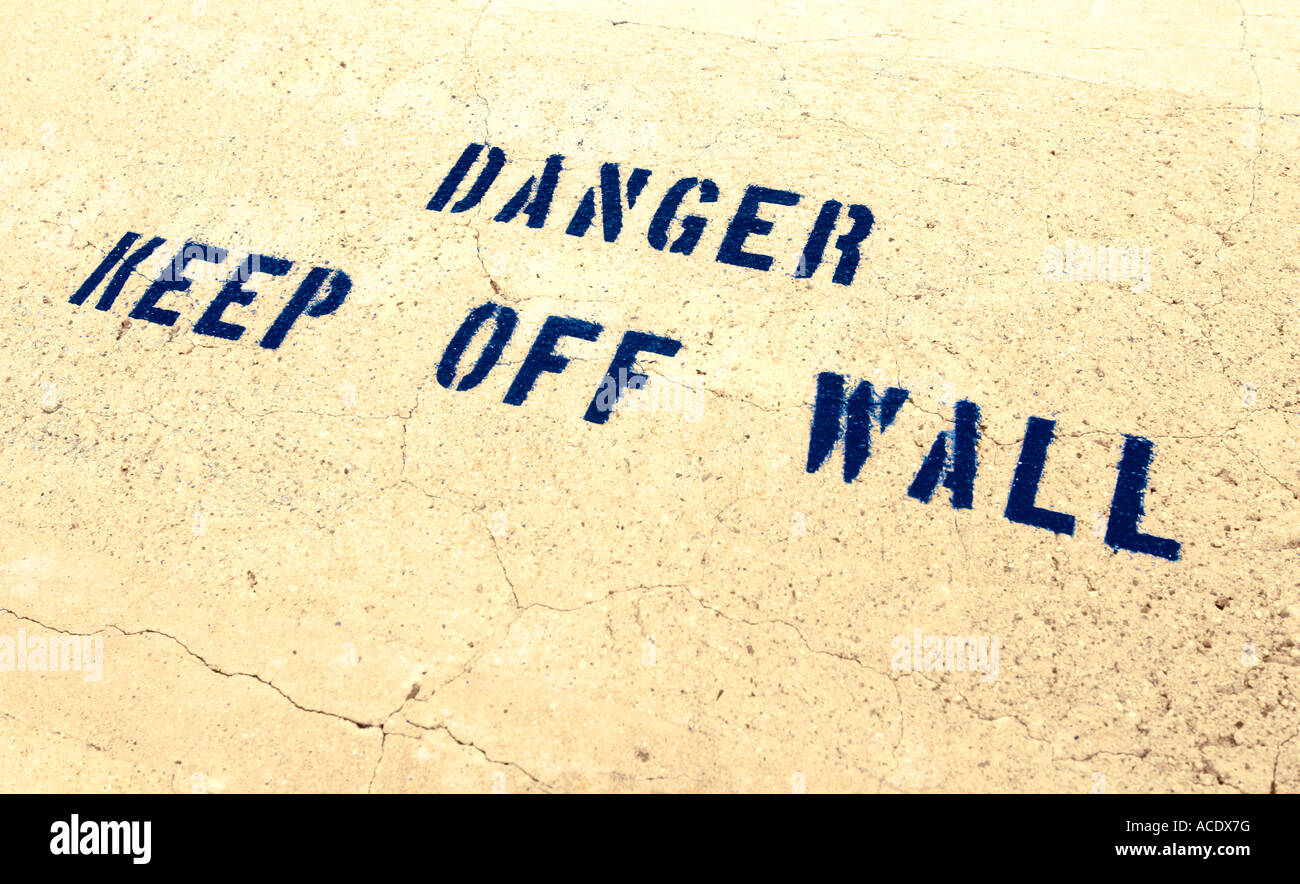 DANGER - KEEP OFF WALL stenciled on a cracked surface Stock Photo - Alamy