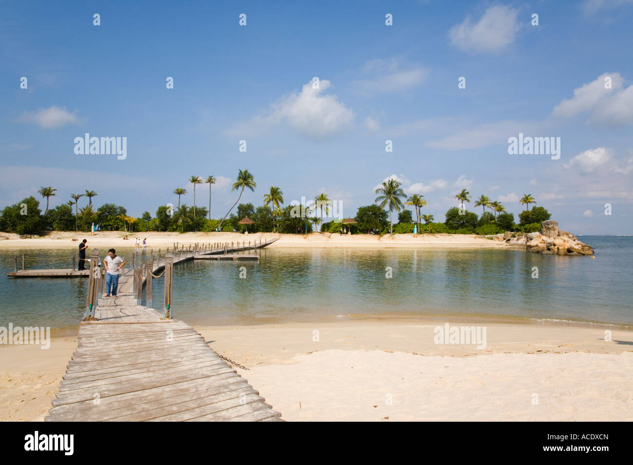 Tropical Siloso beach calm blue sea lagoon and wooden footbridge to ...
