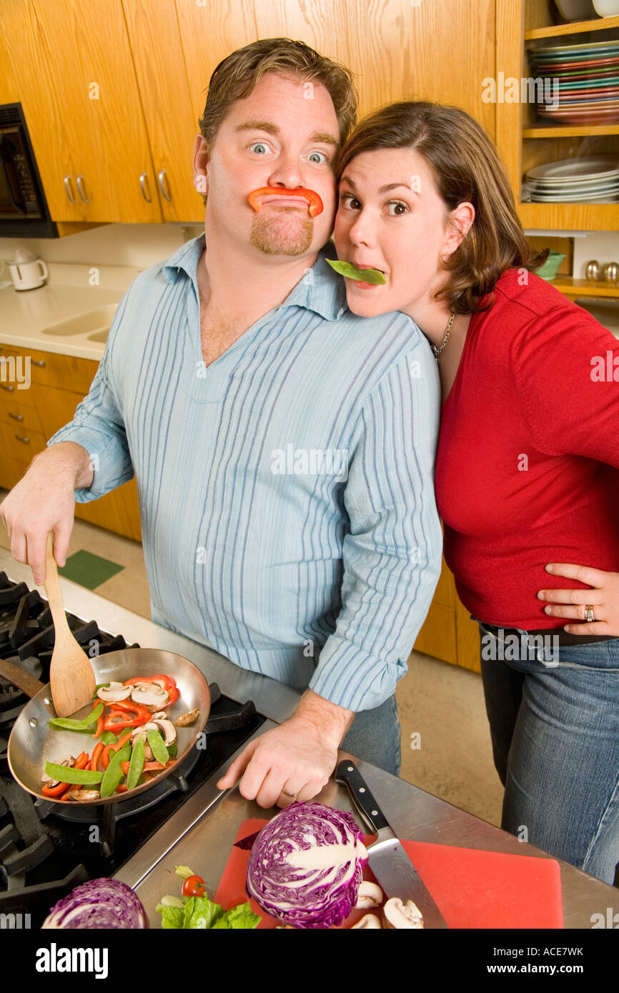 Couple playing with food while cooking Stock Photo - Alamy
