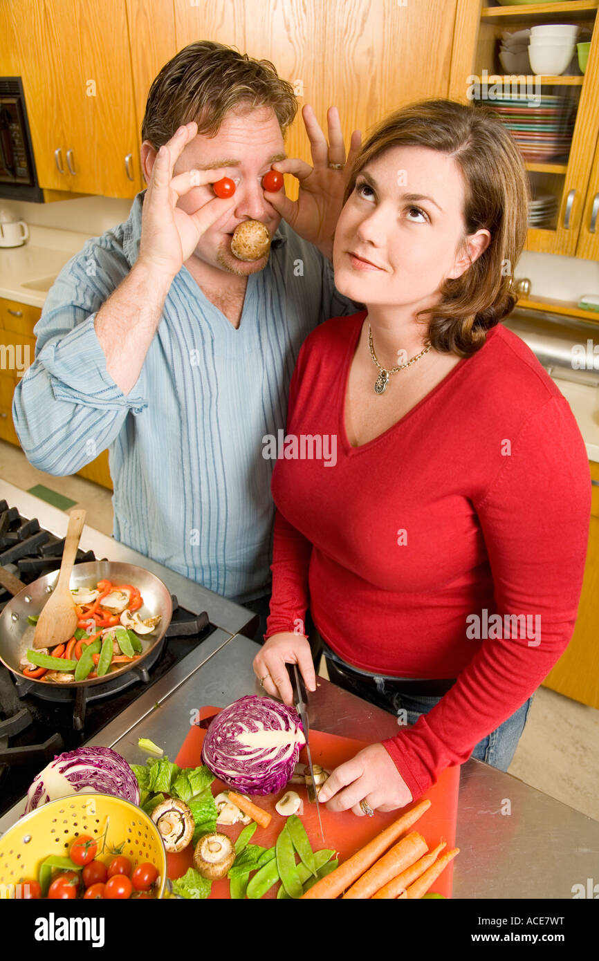 Couple playing with food while cooking Stock Photo - Alamy