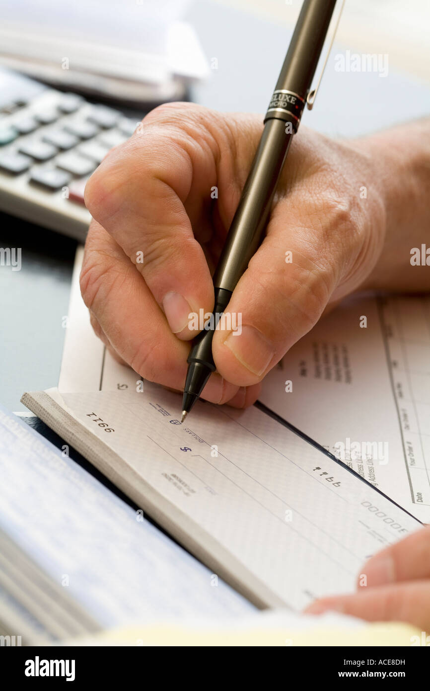 Man writing a check Stock Photo - Alamy