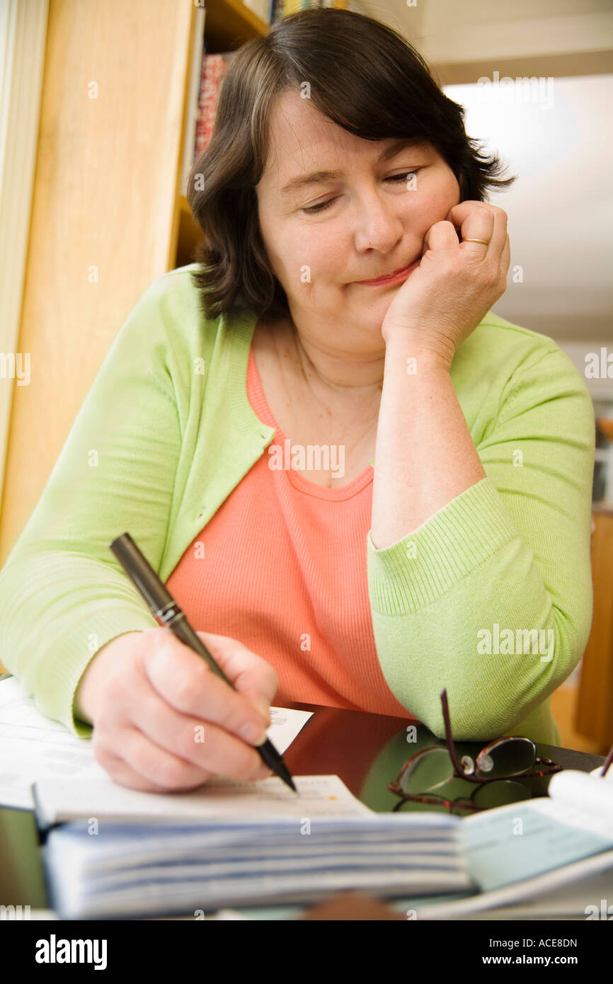Woman writing a check Stock Photo - Alamy