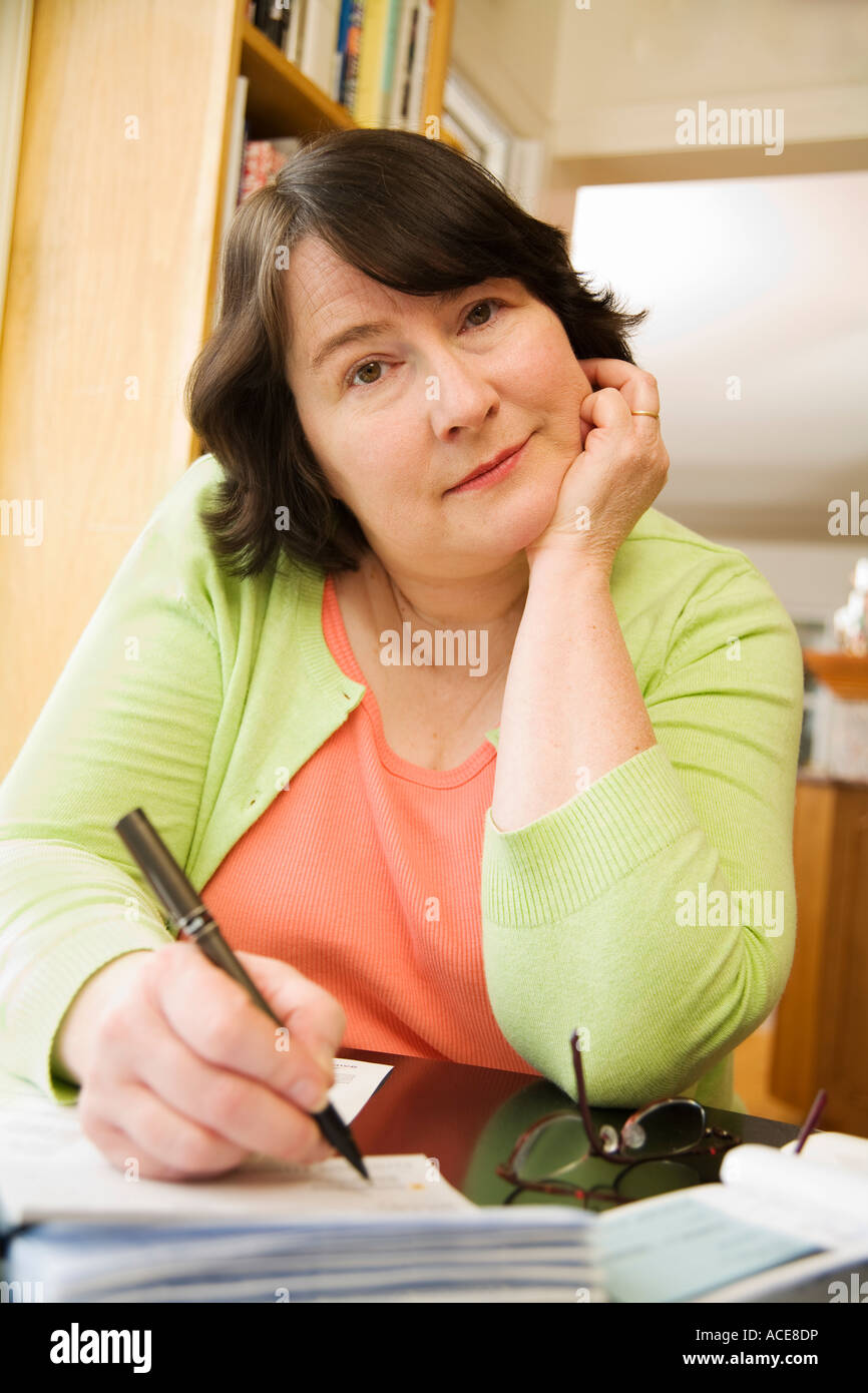 Woman writing a check Stock Photo - Alamy