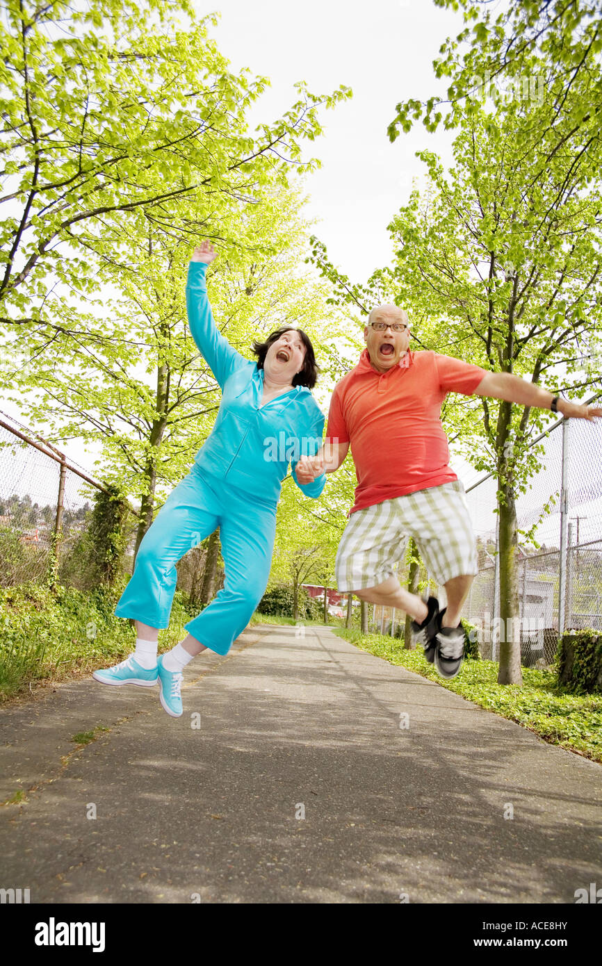 Couple jumping for joy outside Stock Photo - Alamy