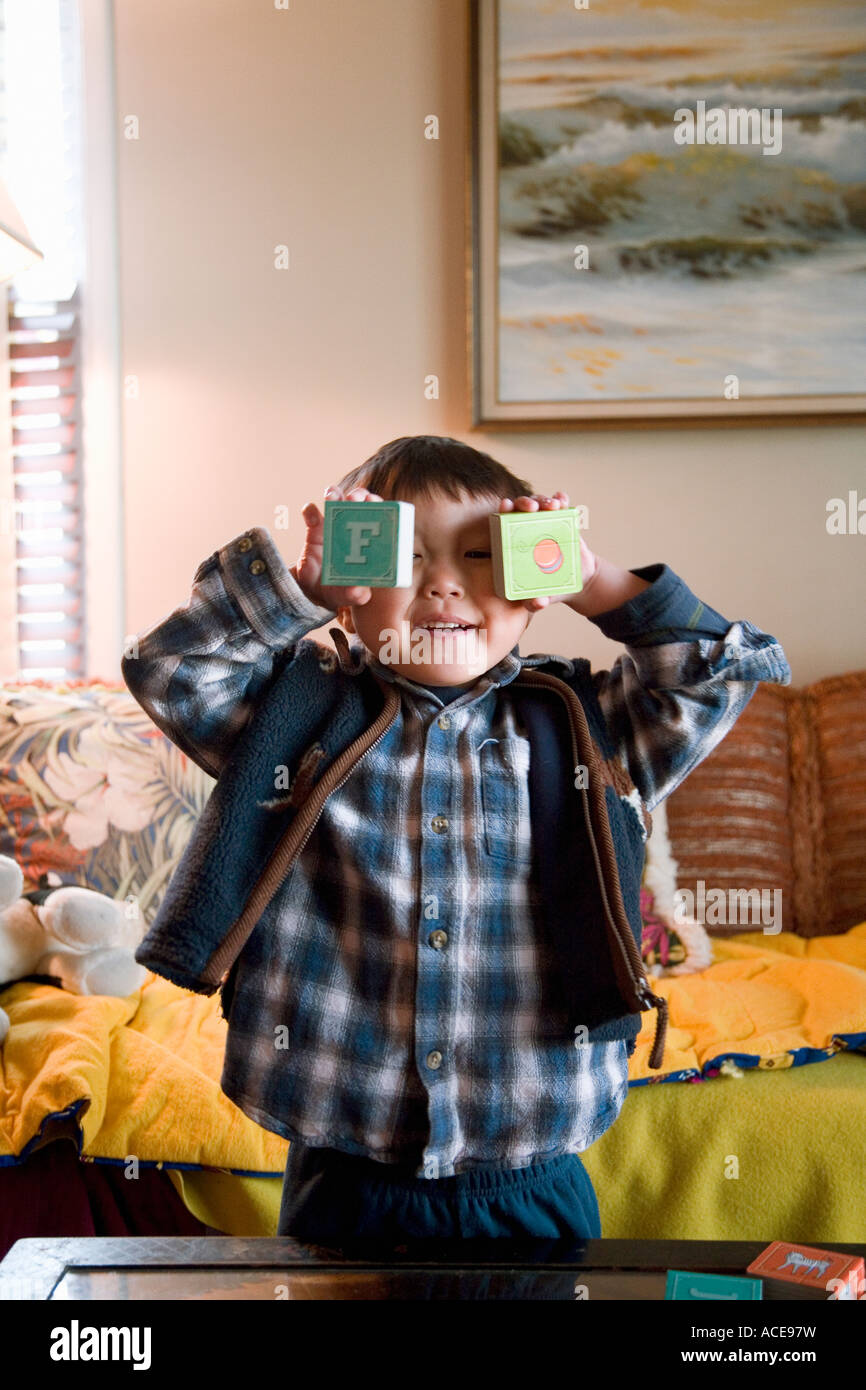 Young boy holding wooden blocks over his eyes Stock Photo - Alamy