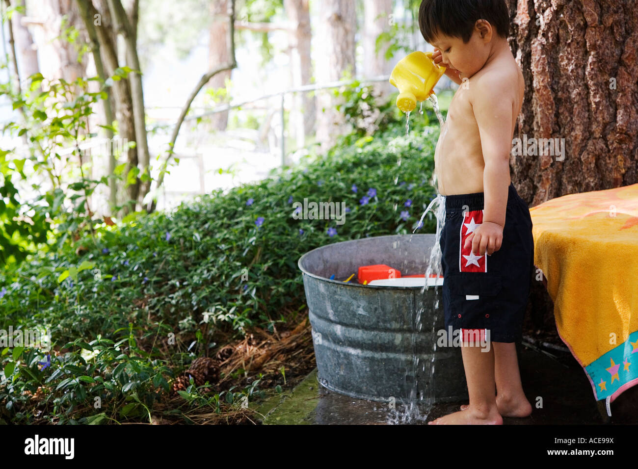 Young boy dumping water on himself Stock Photo - Alamy