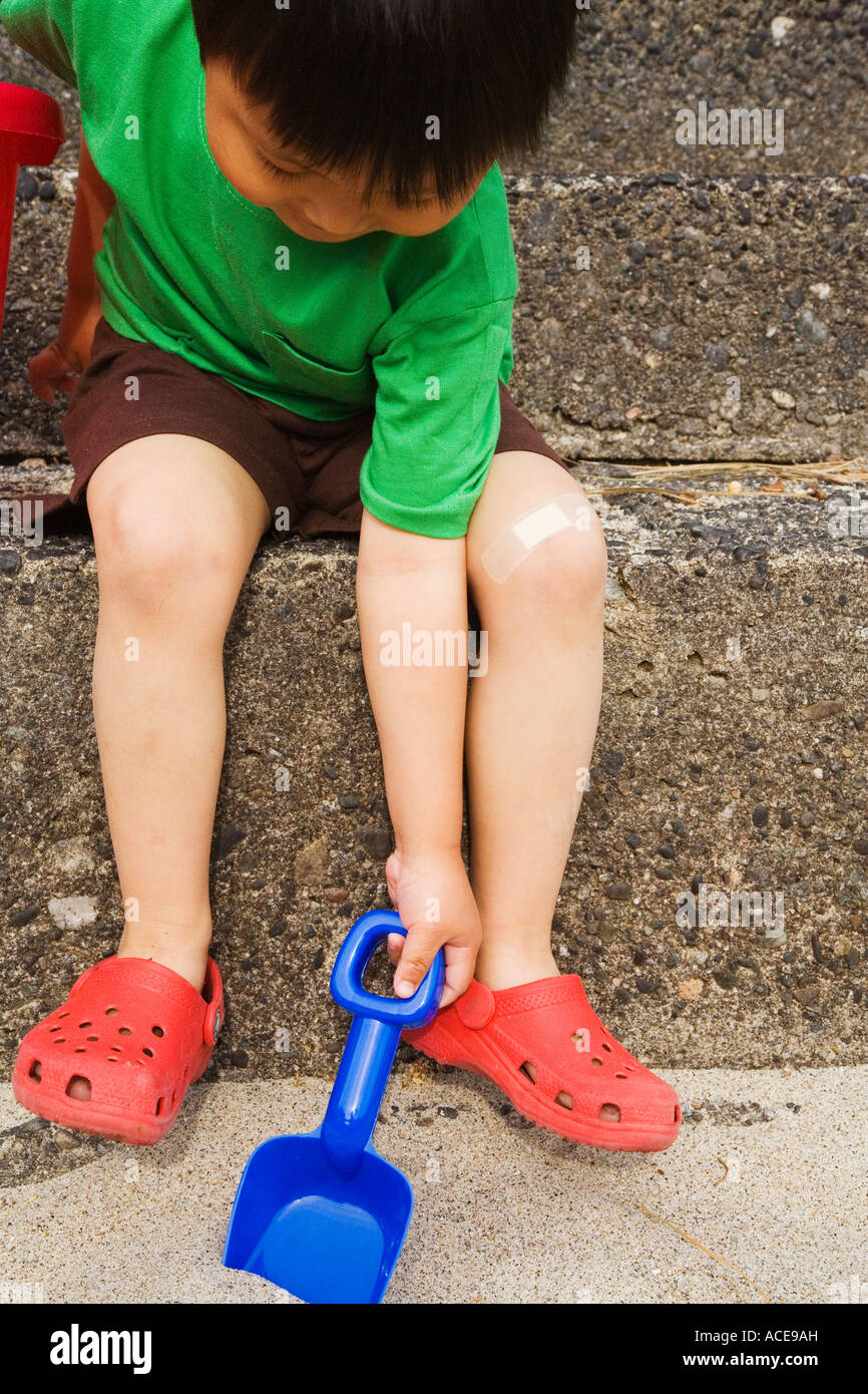 Young boy digging in the sand Stock Photo - Alamy