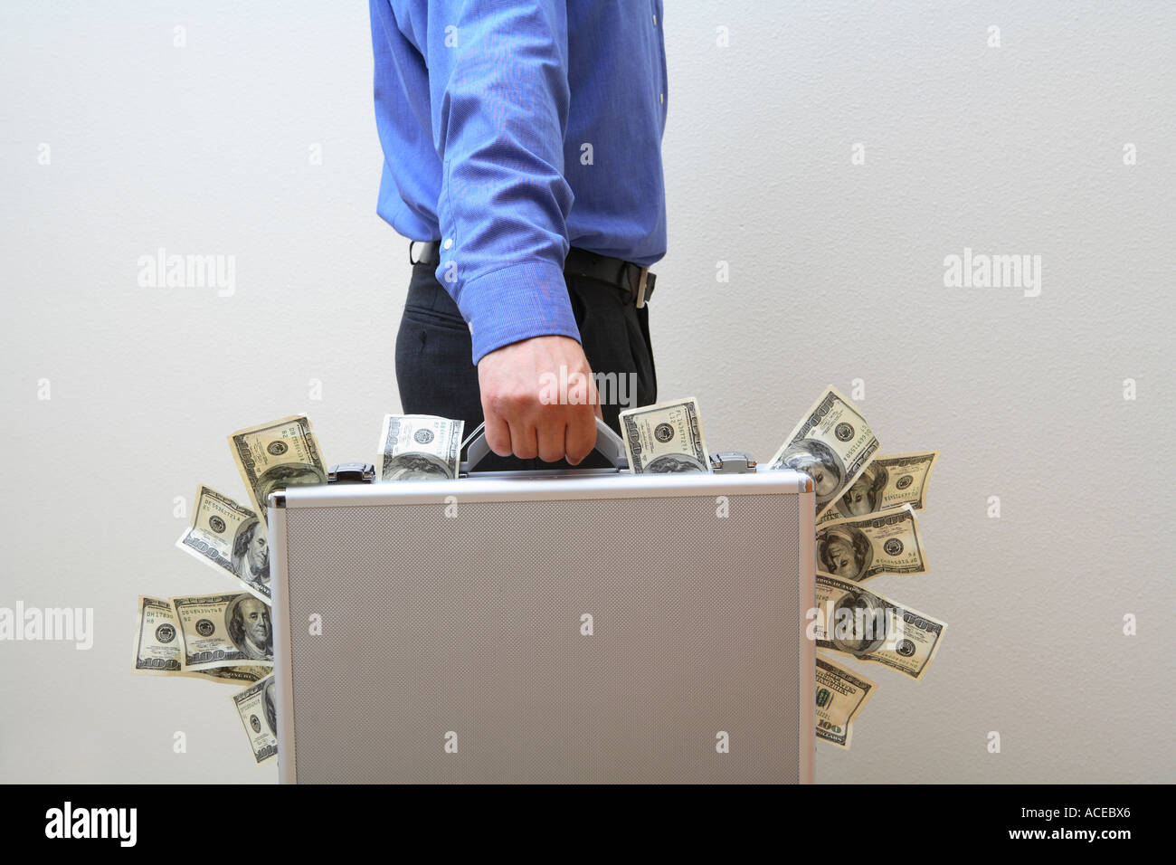 Man holding briefcase stuffed full of money Stock Photo - Alamy