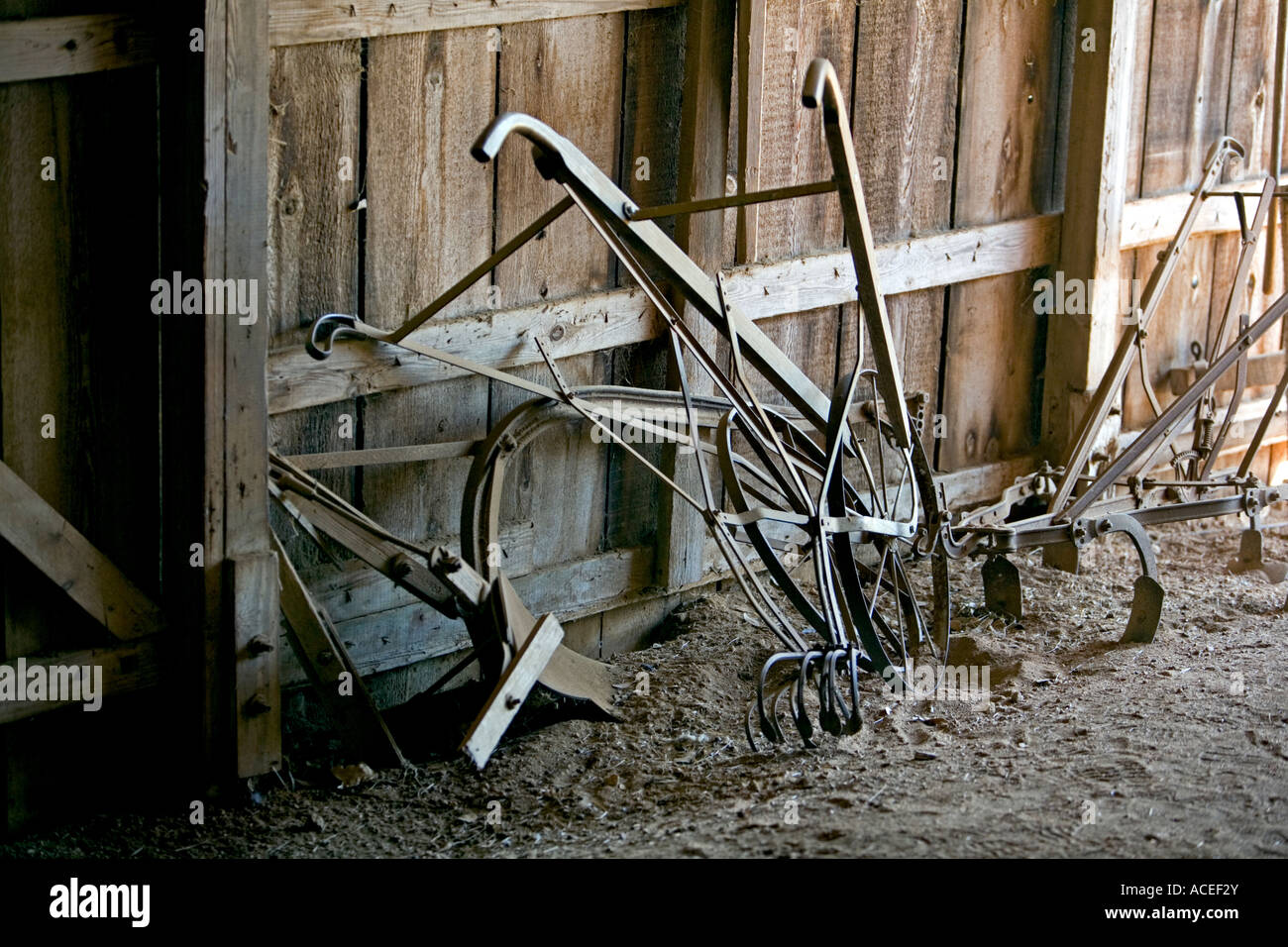 Farm plow implements inside barn tiller and plows Stock Photo - Alamy