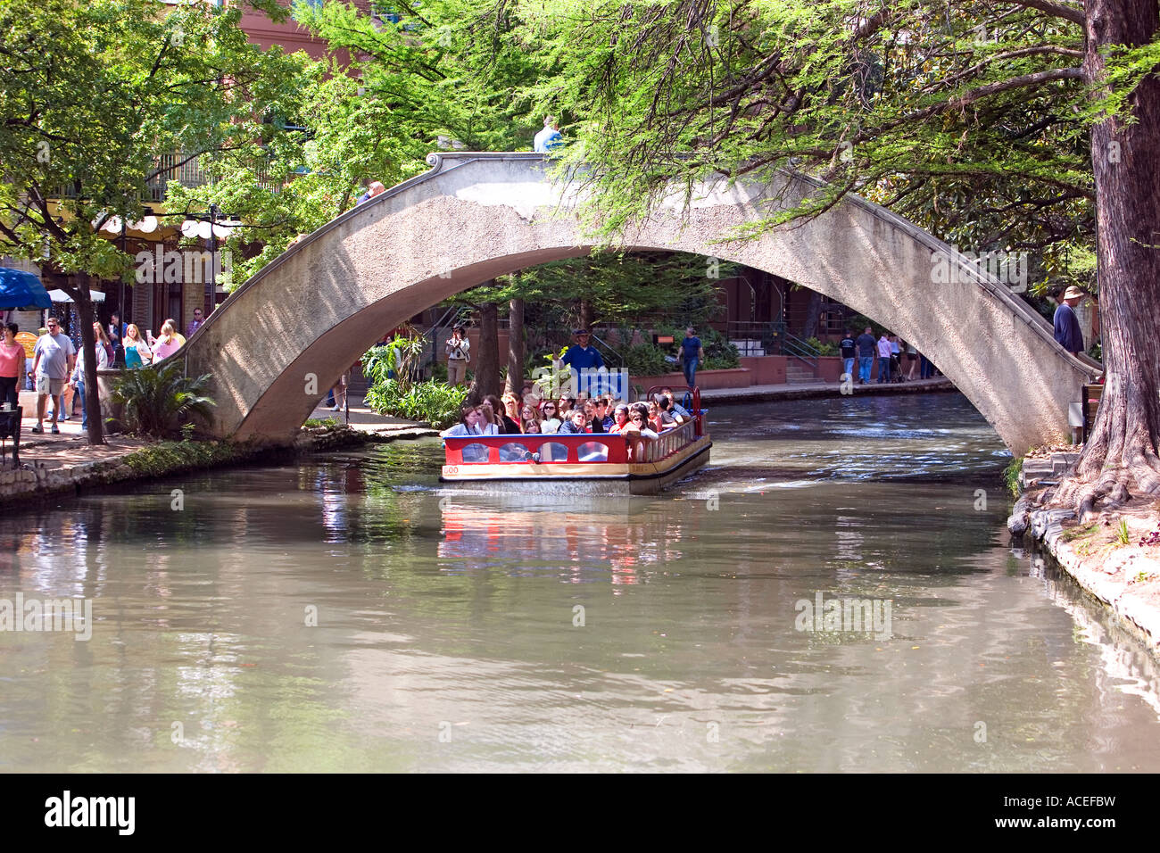 San Antonio Riverwalk tourist barge under bridge Stock Photo - Alamy