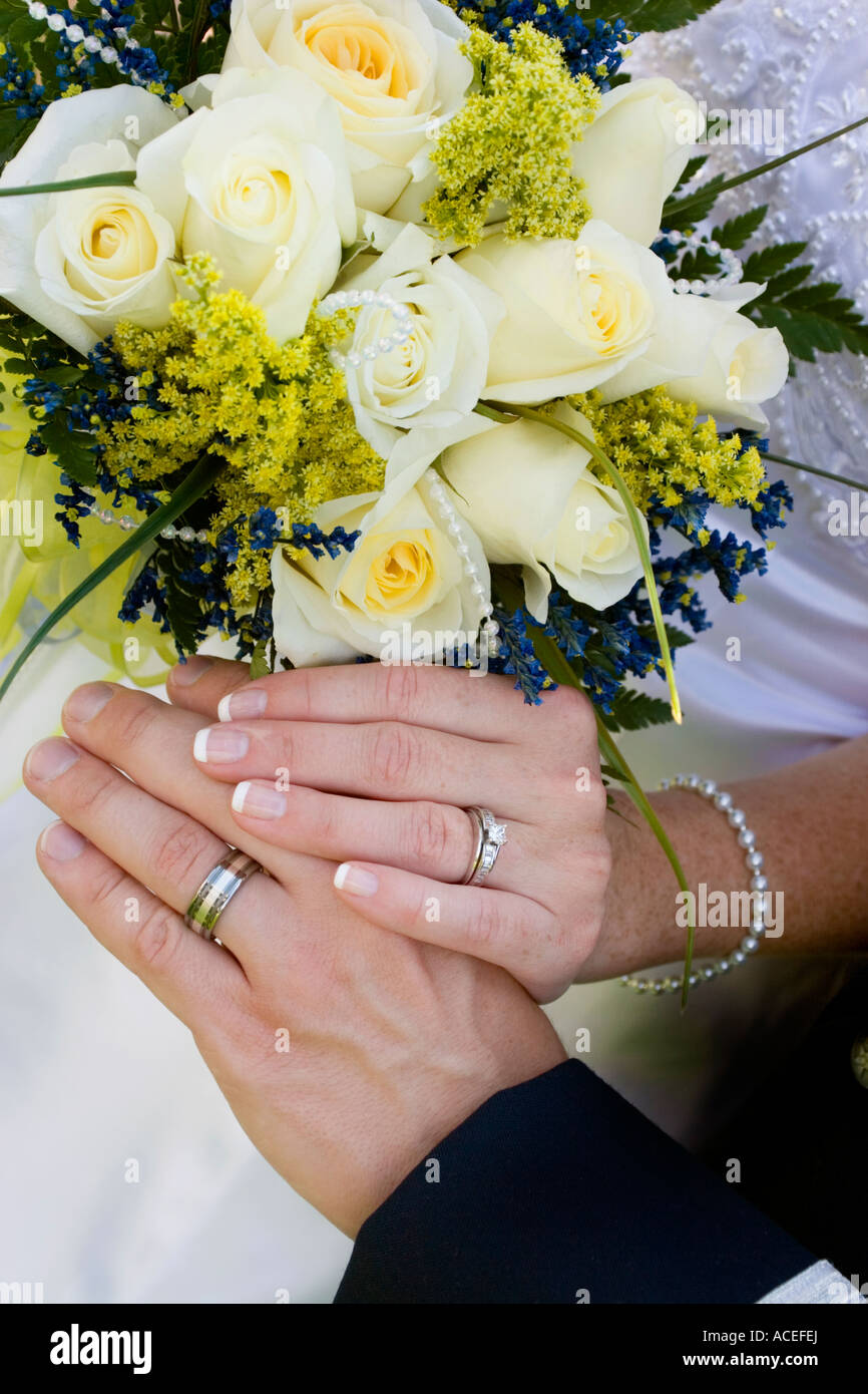 Wedding hands flowers rings. Bride and Groom holding hands by flower ...