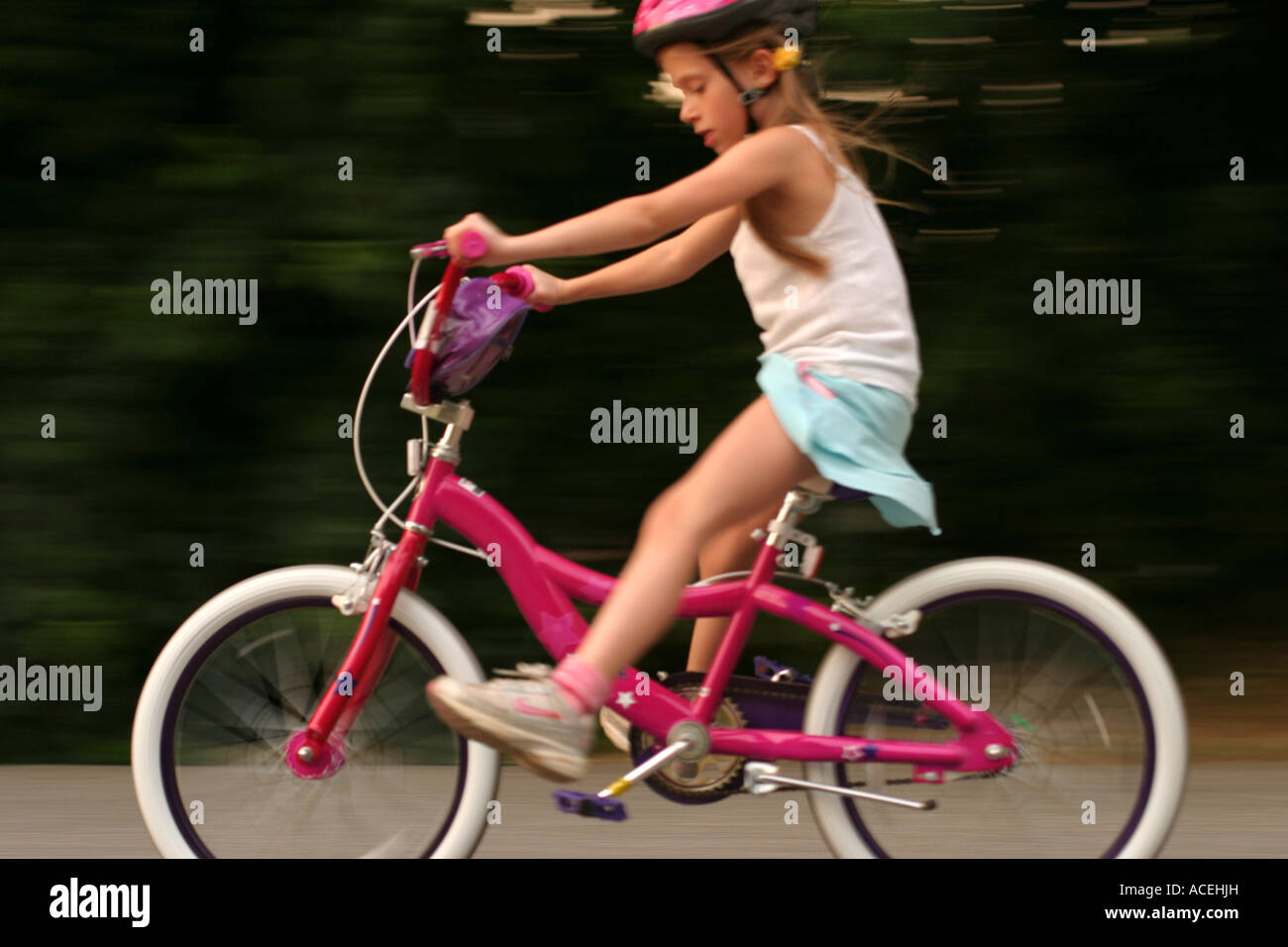 young girl having fun riding pink bike Stock Photo - Alamy