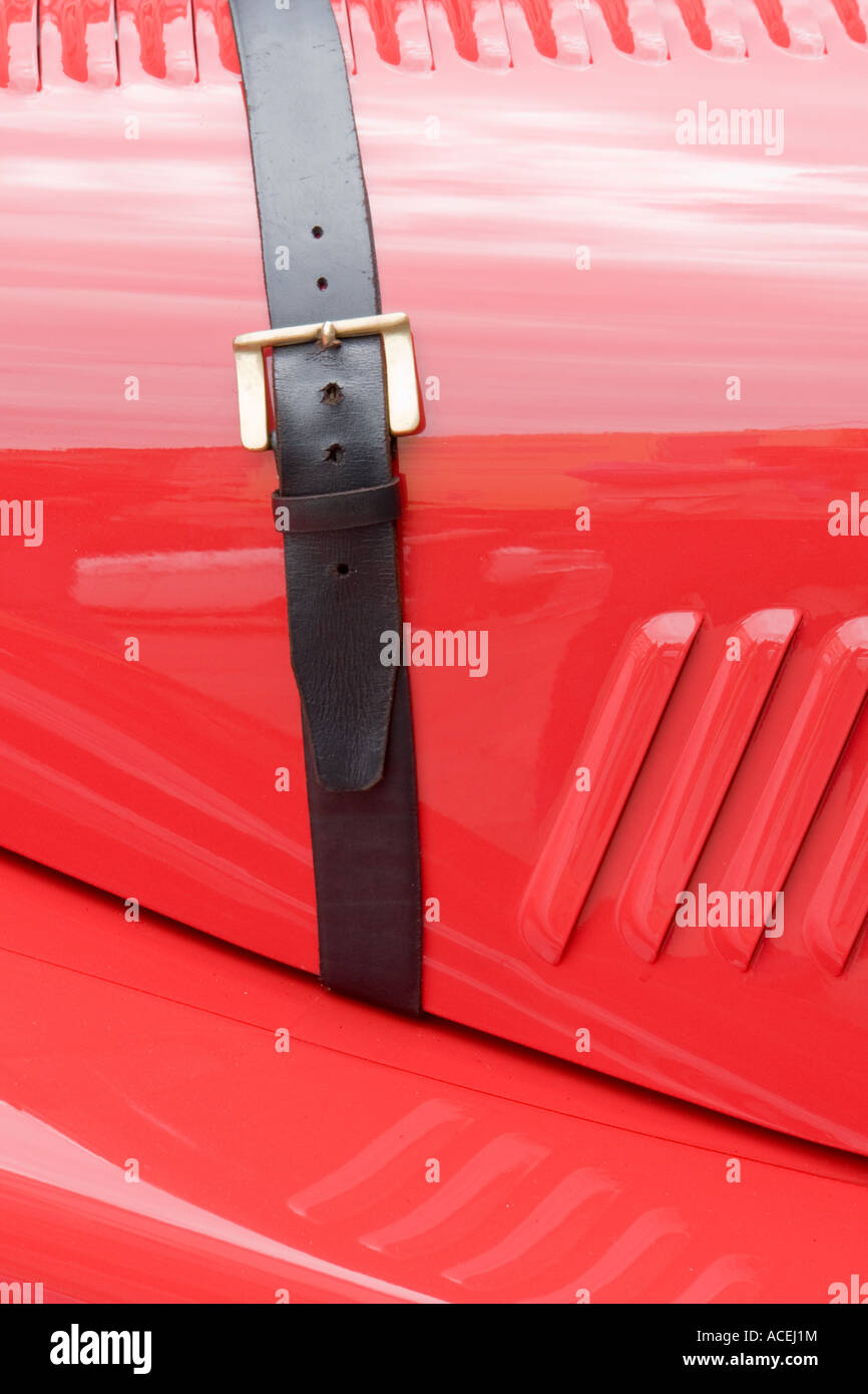 Shiny bright red car bonnet louvres detail with belt holding engine ...