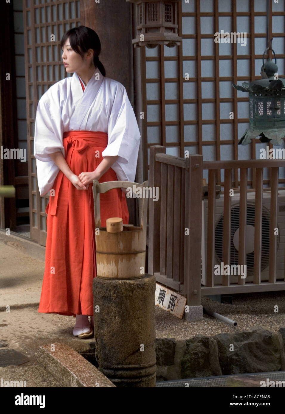 A miko female maiden shrine assistant in red and white attire awaiting ...