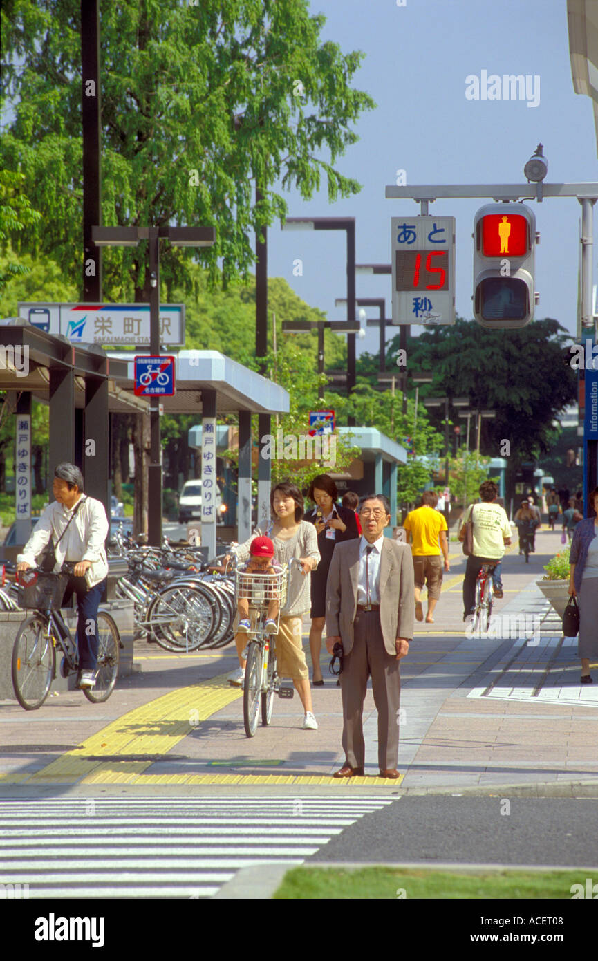 People waiting at crosswalk as traffic signal counts down the seconds ...