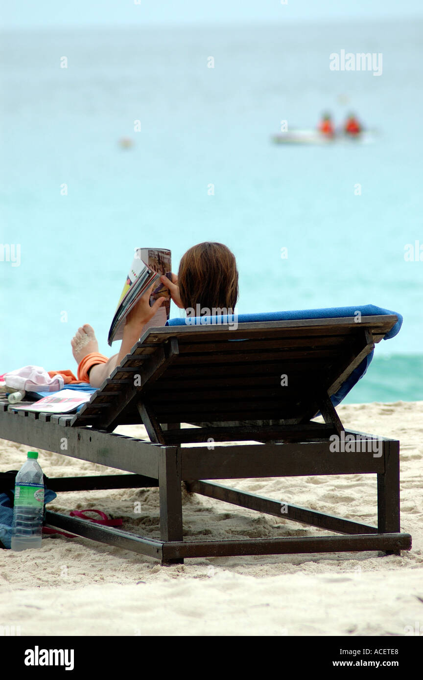 Woman on sliding bench by beach Stock Photo - Alamy