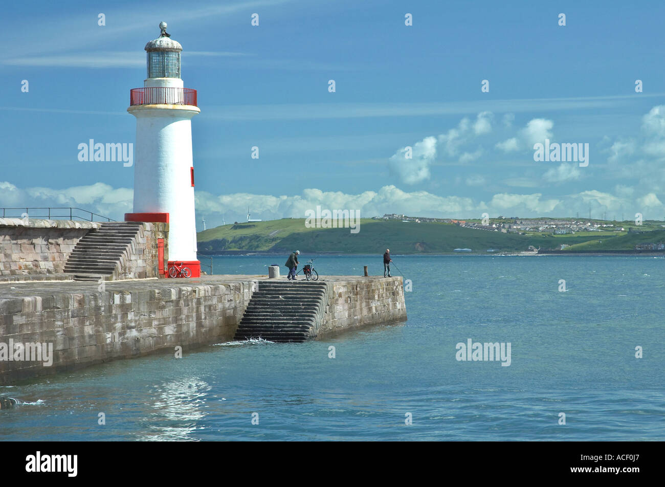 Fishermen and Lighthouse on the Dock Wall Stock Photo - Alamy