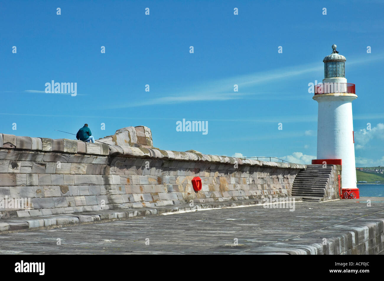 Fisherman and Lighthouse on the Dock Wall Stock Photo - Alamy