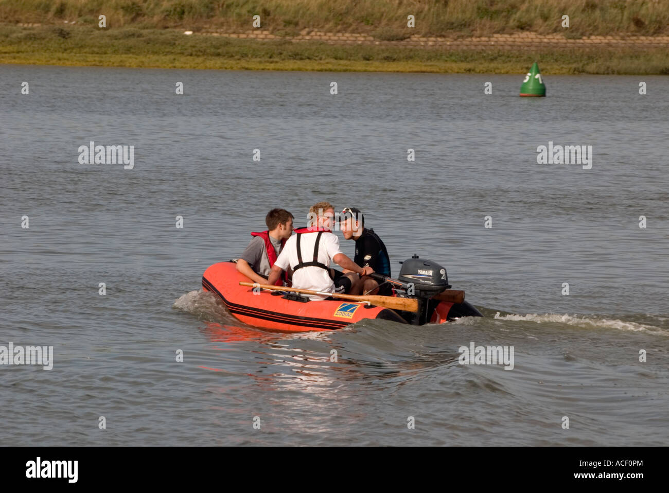 Three People in Red Inflatable Dinghy with Outboard Stock Photo - Alamy