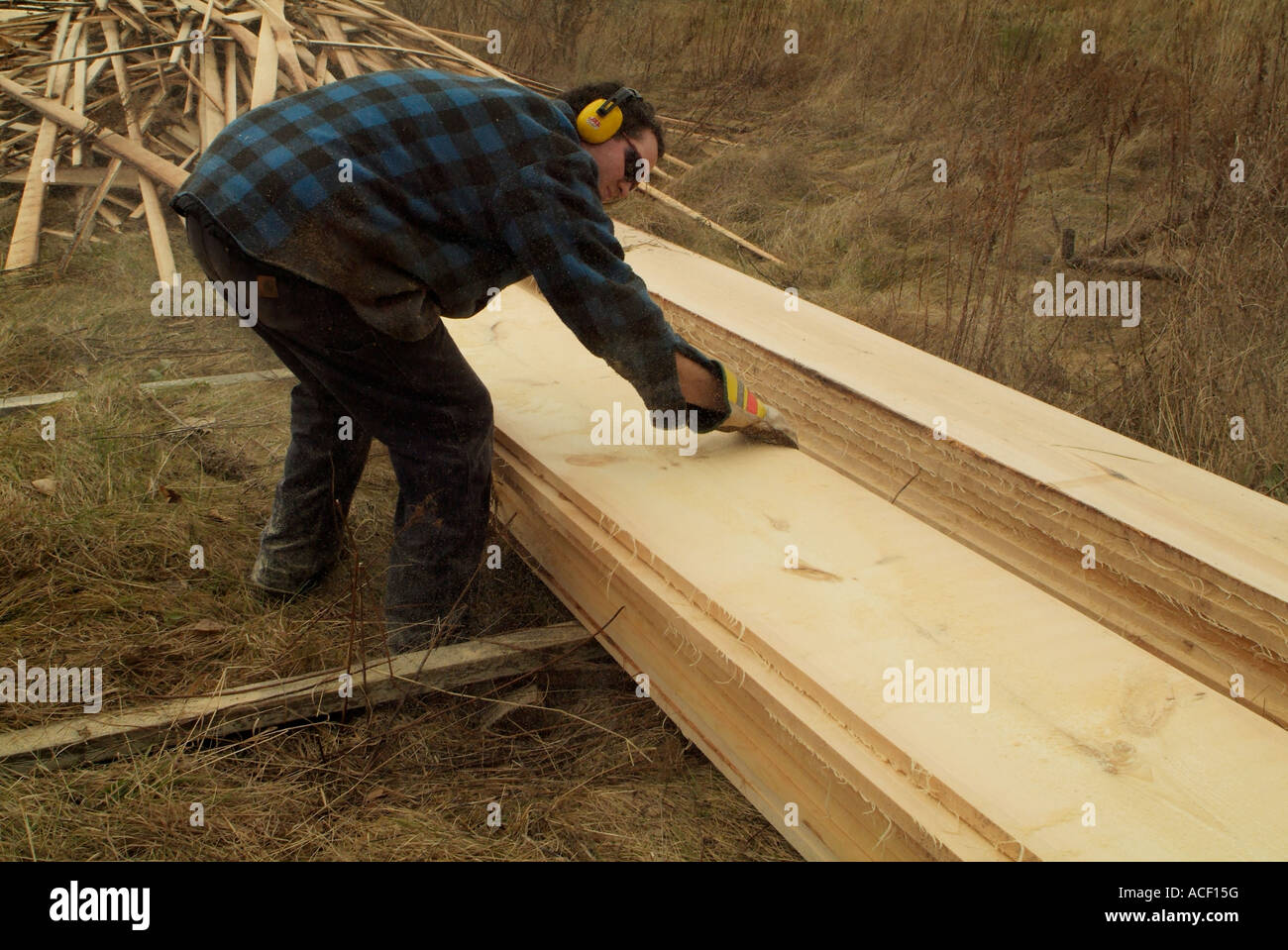 Man piling planks Stock Photo - Alamy