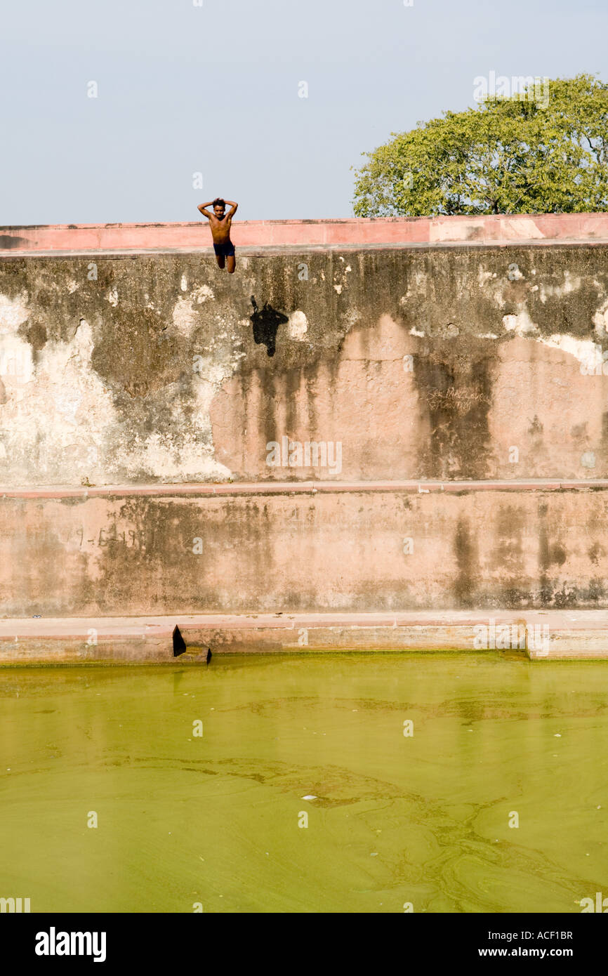 young man jumping from the wall to green water Stock Photo - Alamy