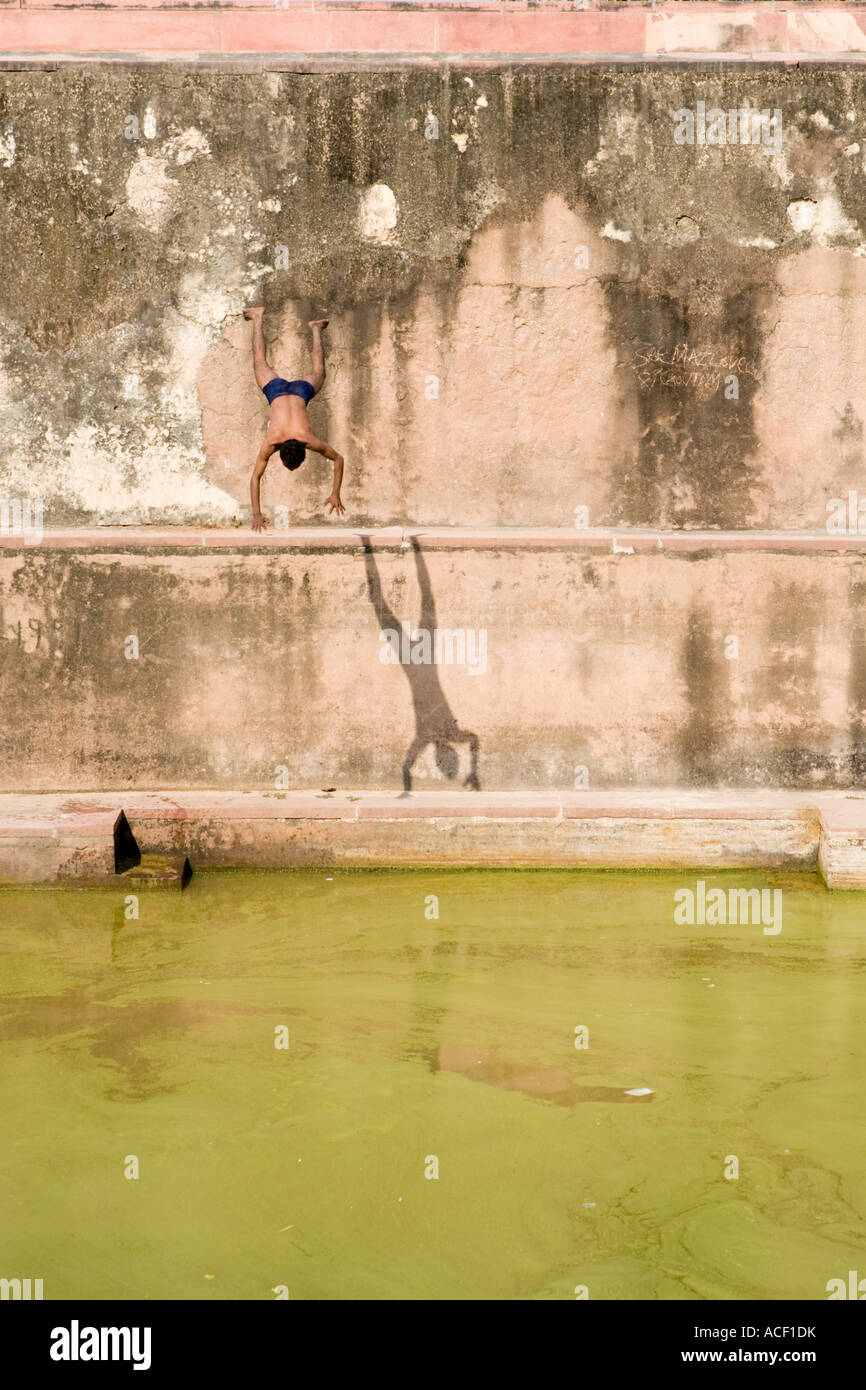 young man jumping from the wall to green water Stock Photo - Alamy