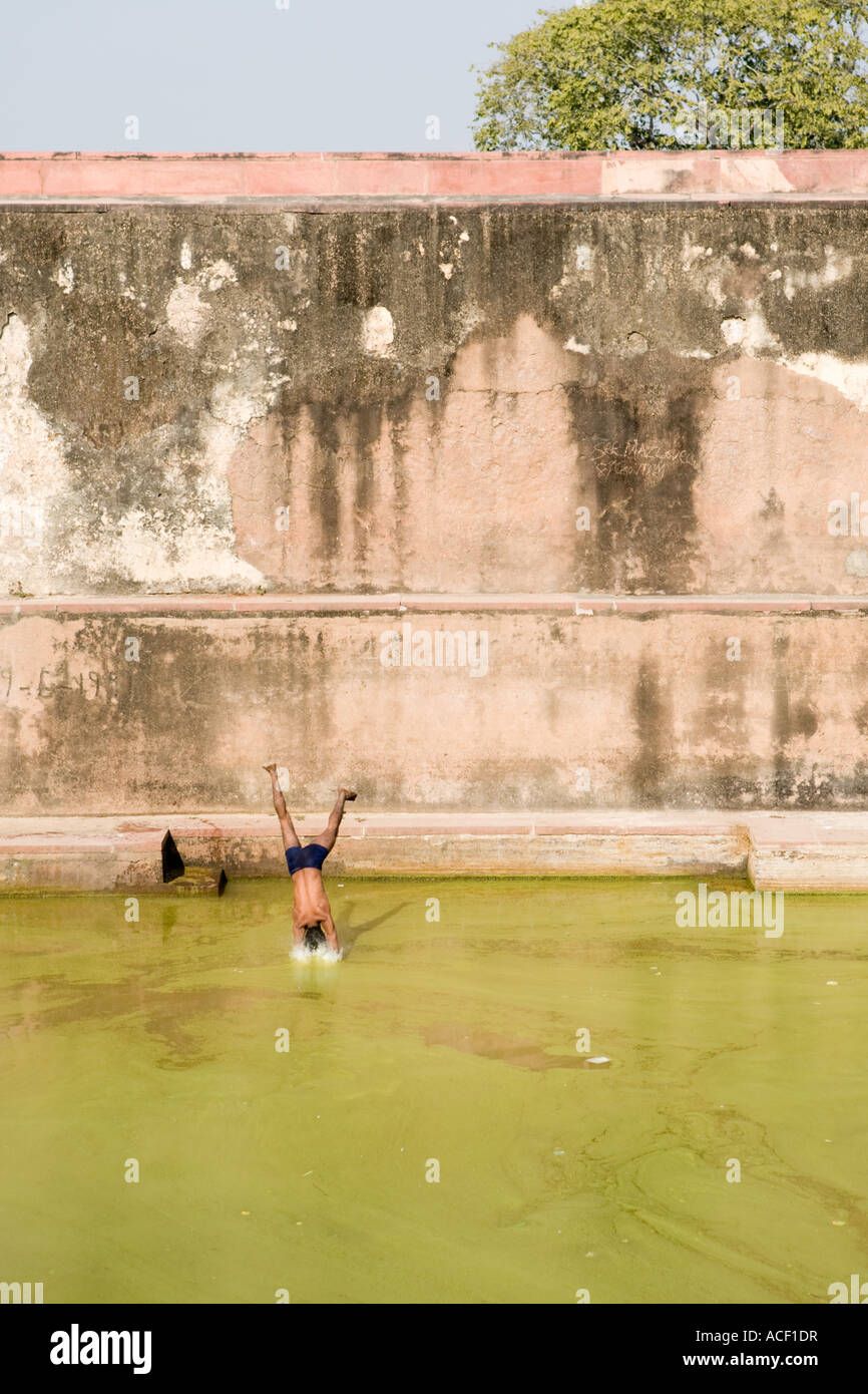 young man jumping from the wall to green water Stock Photo - Alamy