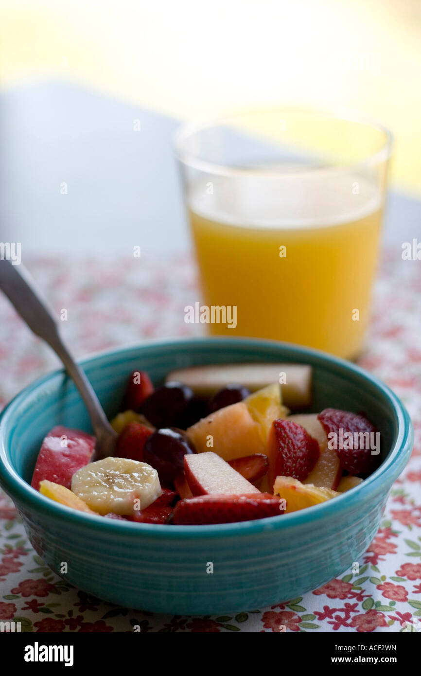 bowl of mixed fruit and a glass of orange juice Stock Photo - Alamy