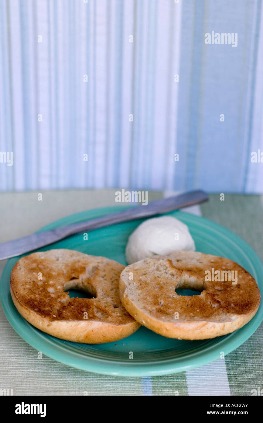 toasted bagels on plate with cream cheese Stock Photo - Alamy
