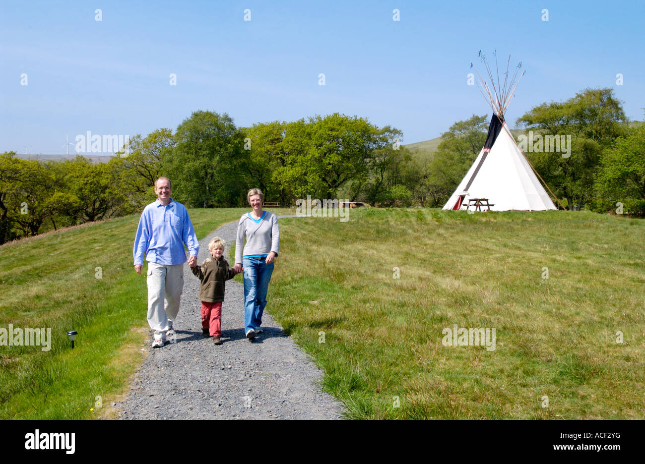 Family group on camping holiday under canvas at specialist teepee ...