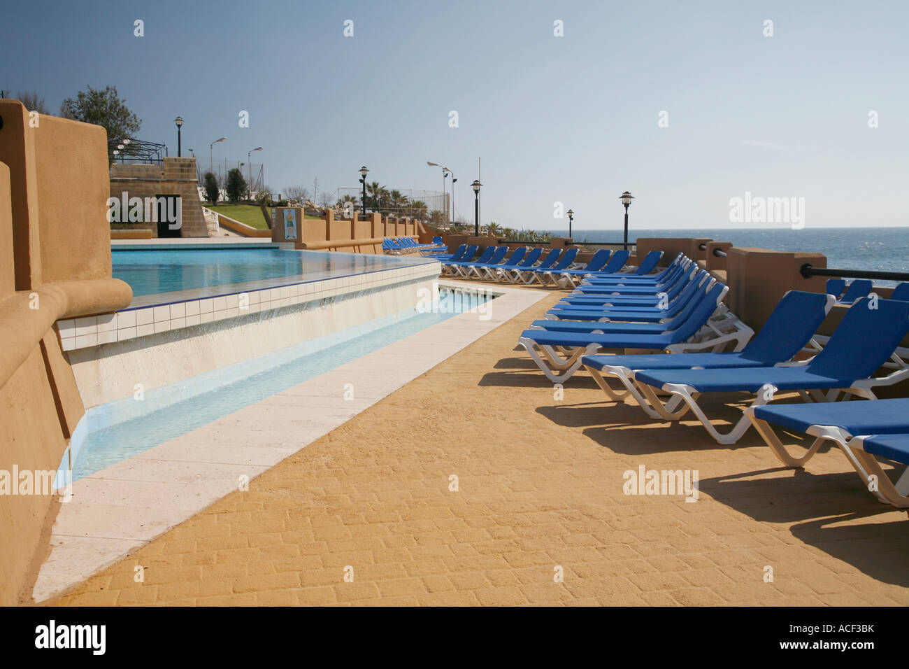 Blue Sunbeds by a swimming pool at an hotel Stock Photo - Alamy