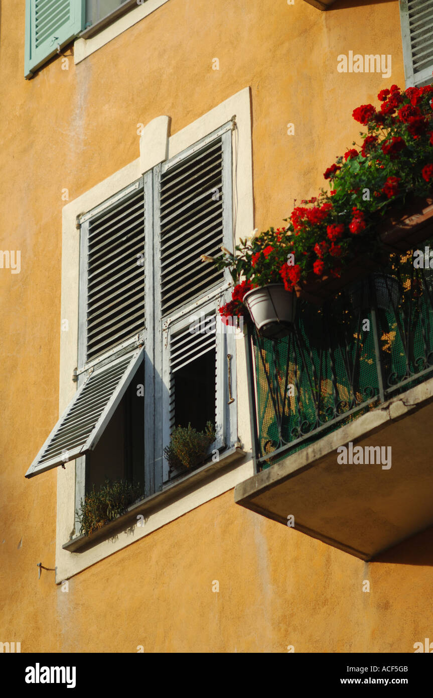 A window with flowers and balcony in a building in the Old Town of Nice ...
