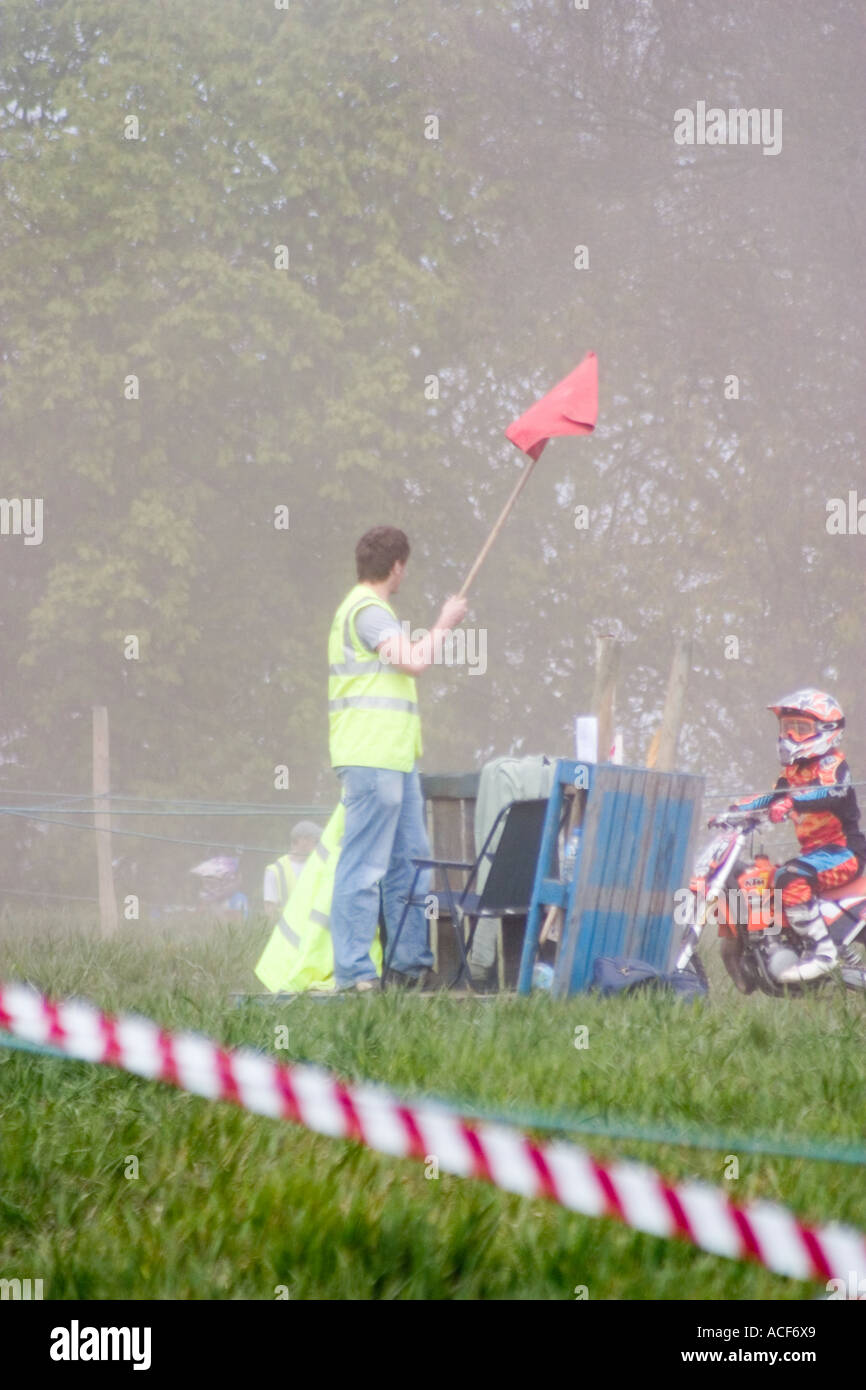 Marshall at Motocross race waving red flag to stop race Stock Photo - Alamy